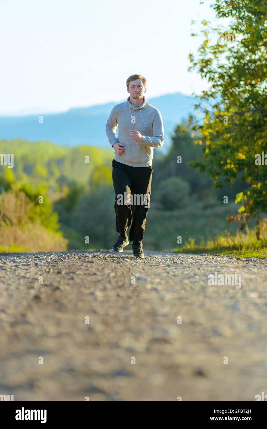 Running man jogging in rural nature at beautiful summer day. Sport ...