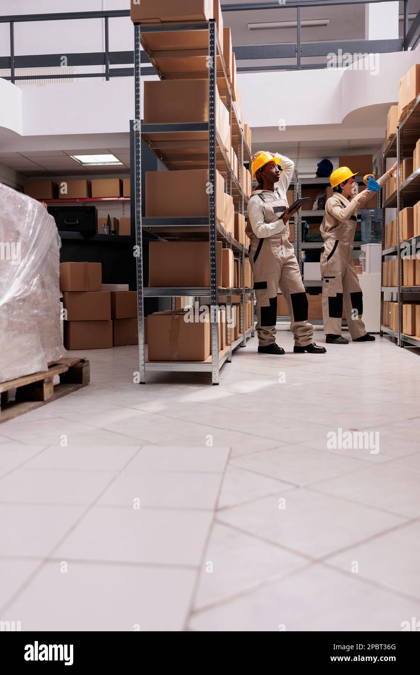 Frustrated african american warehouse manager solving distribution problems and holding hands on ...