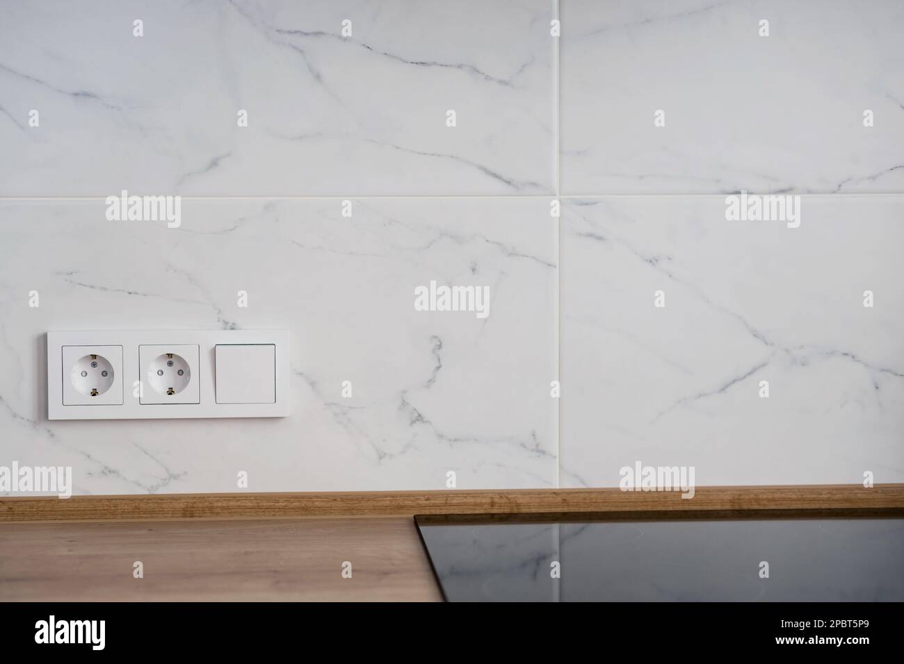 two sockets and a switch in the kitchen wall of tiles. home interior ...