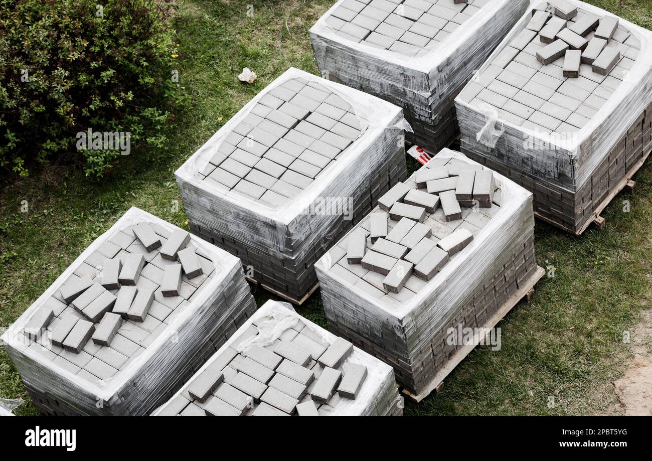 Pallets with stacked gray paving slabs. Stack of paving slabs in ...