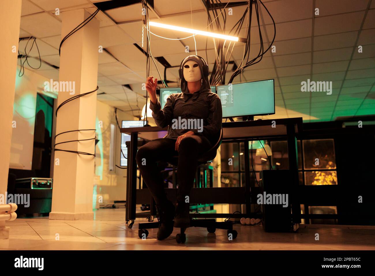 Hacker with mask looking at holographic image in augmented reality ...