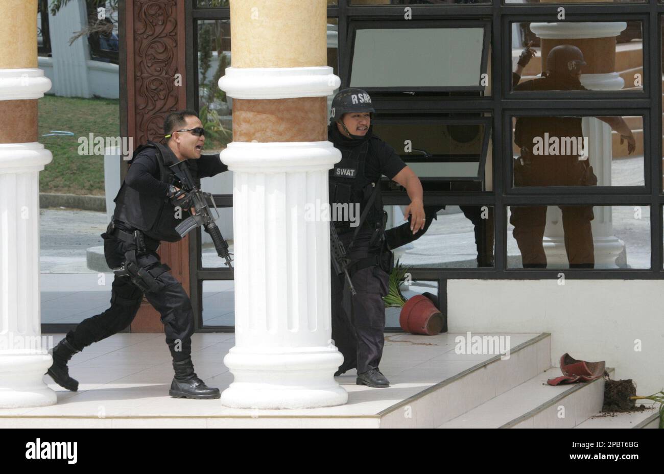 SWAT members of the Philippine National Police storm the Taguig City ...