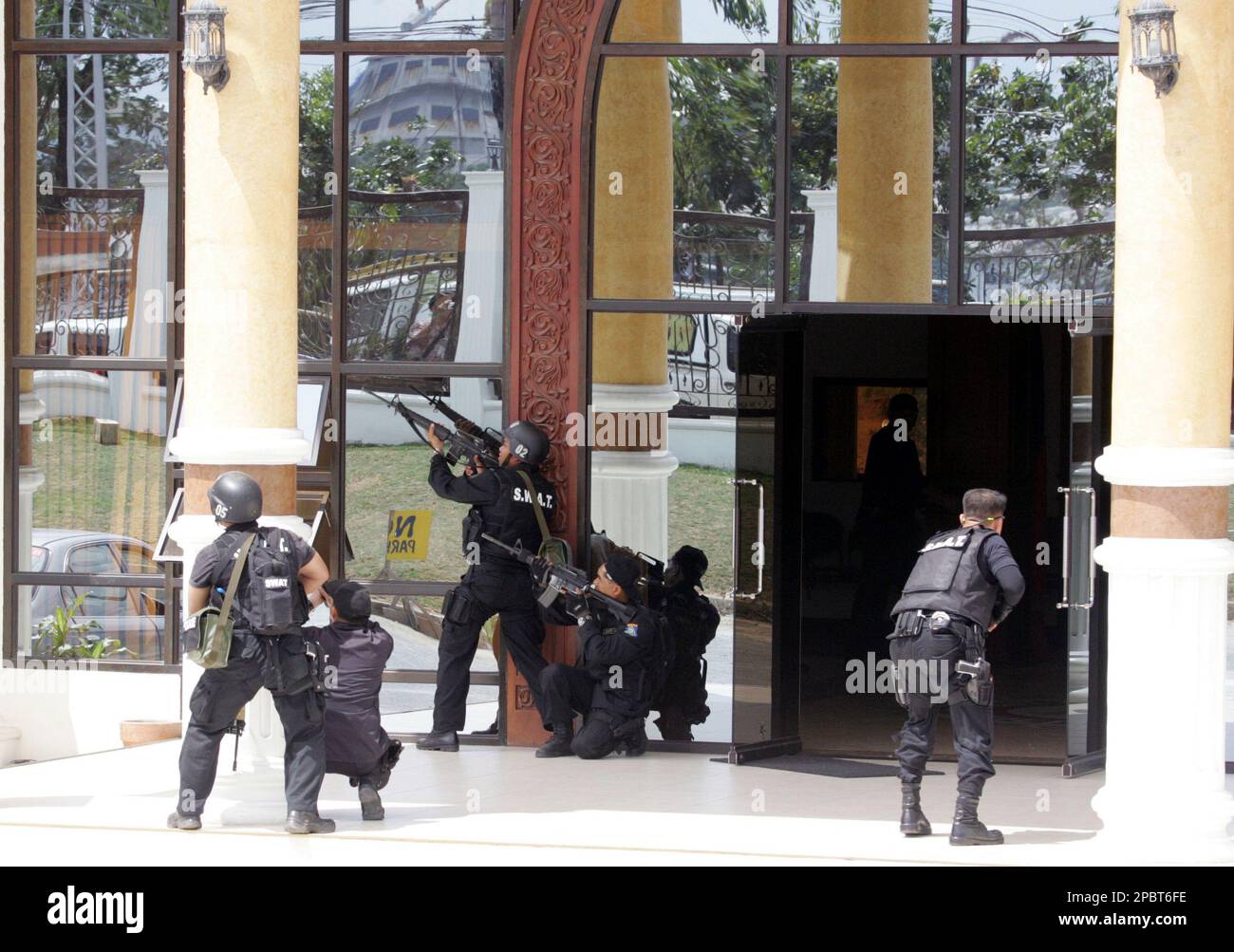 SWAT members of the Philippine National Police aim their rifles at the ...