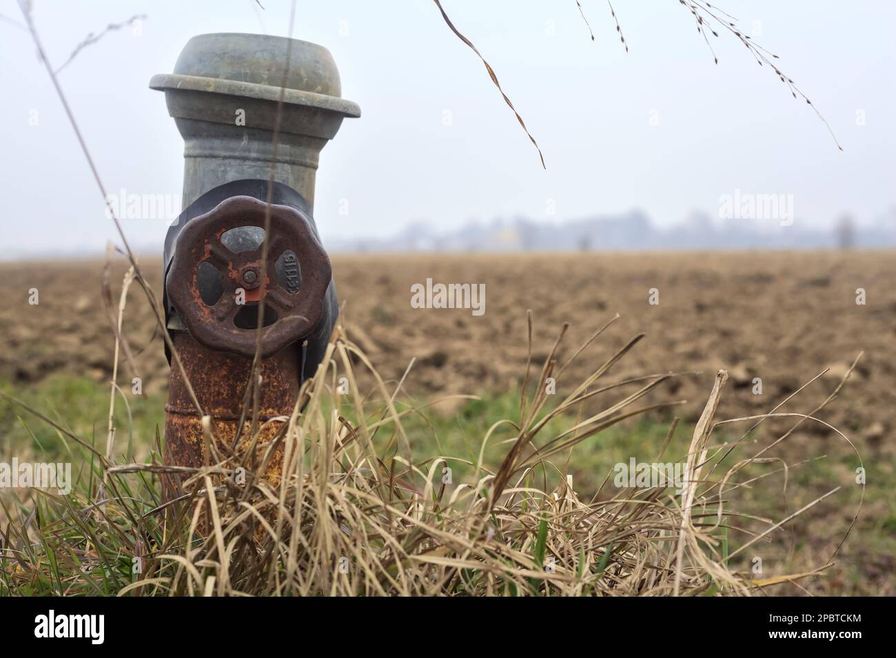 Rusty faucet in a field seen up close Stock Photo - Alamy