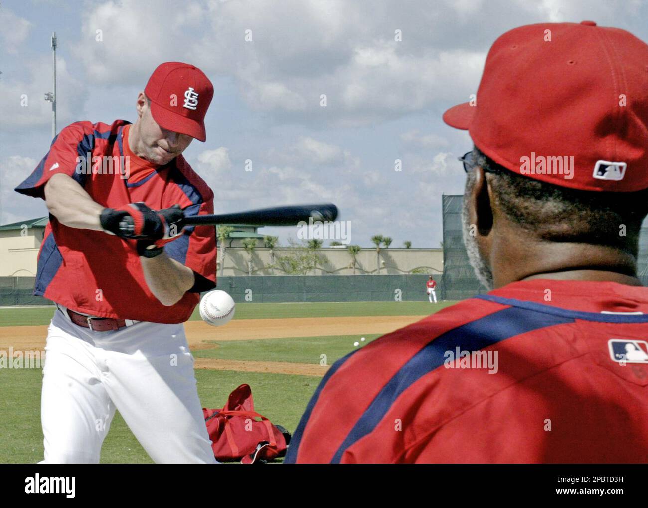 St. Louis Cardinals' Jim Edmonds, left, hits slow pitch with batting ...