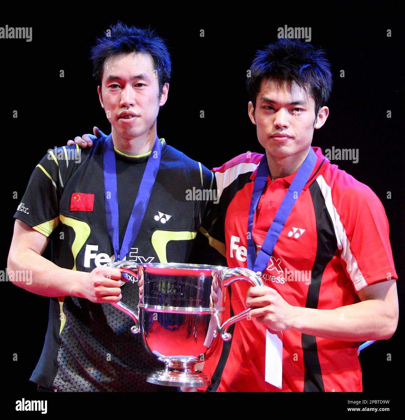 China's Lin Dan, right, lifts the All England Badminton trophy he has ...