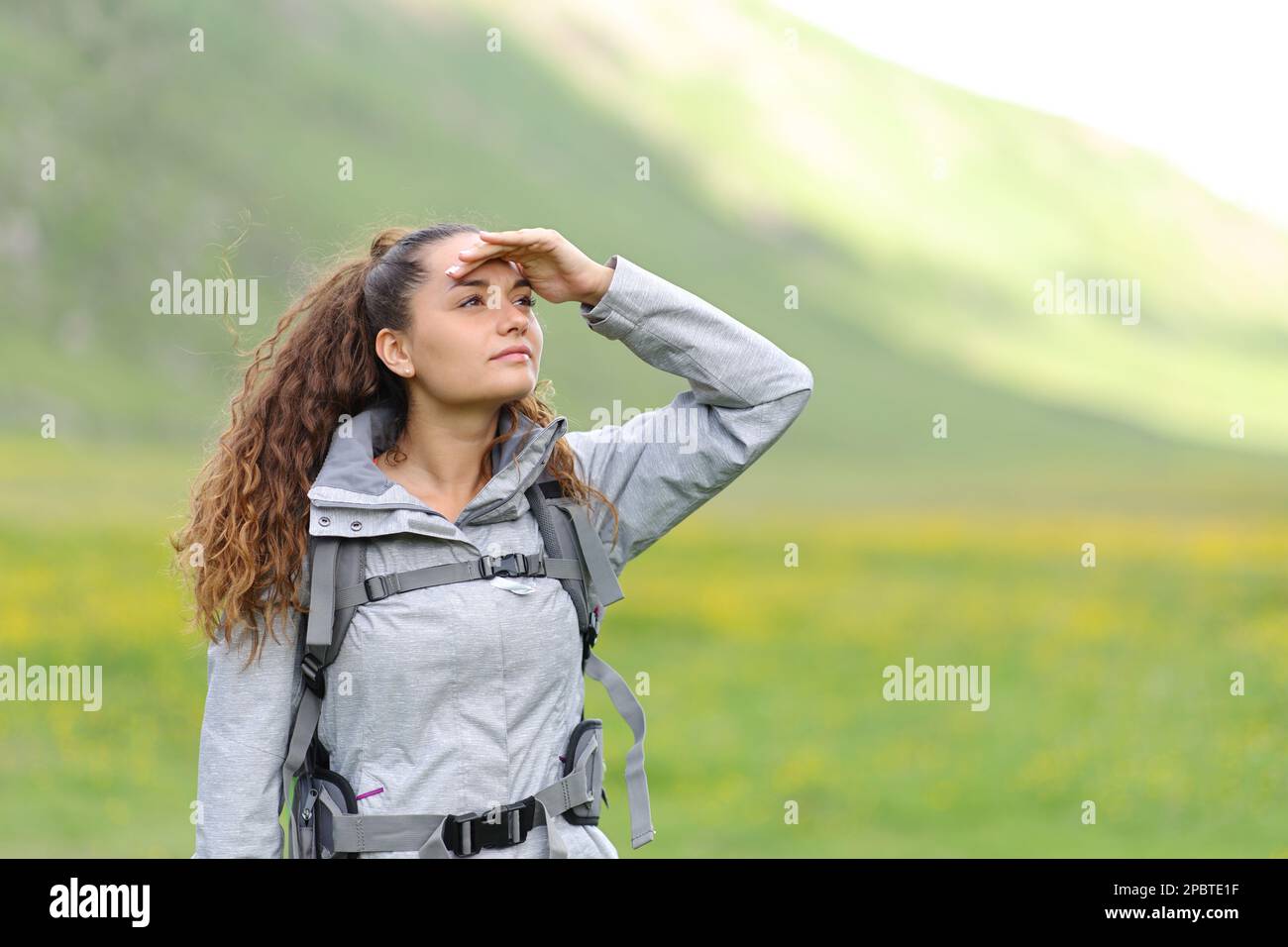 Hiker searching with hand on forehead in nature Stock Photo - Alamy