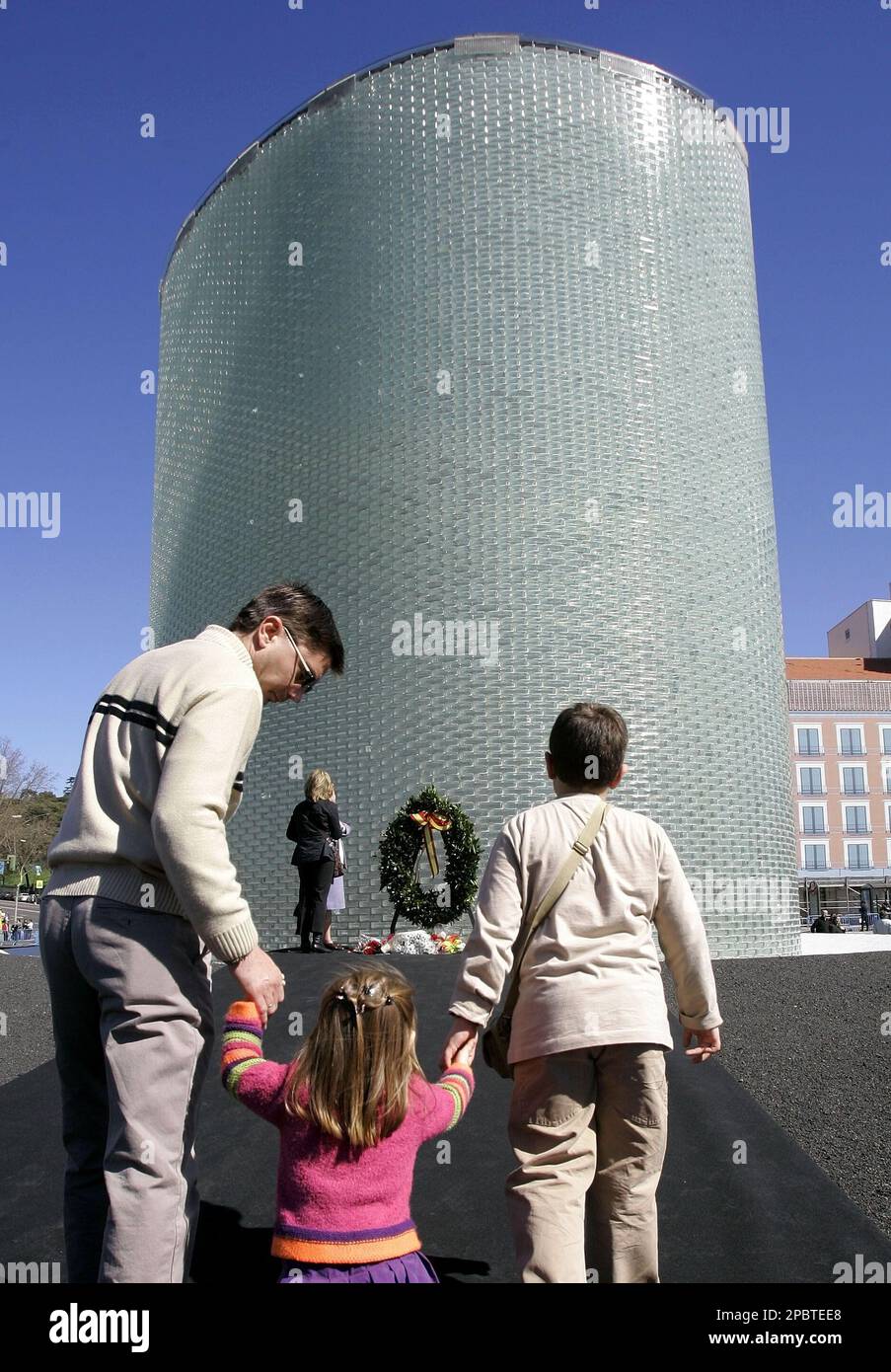 Relatives walk to an 11-meter-tall (35-foot-tall) glass cylinder with a ...