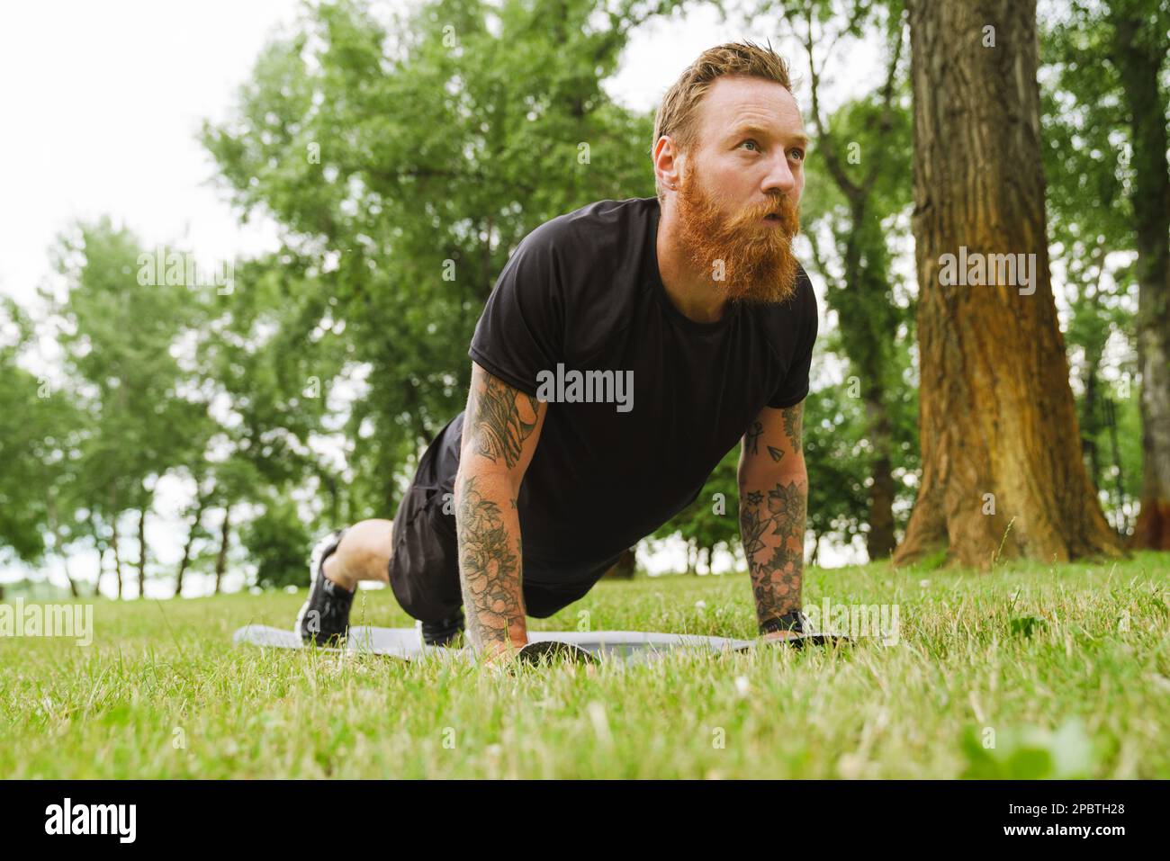 Ginger bearded man doing exercise during workout in park outdoors Stock ...