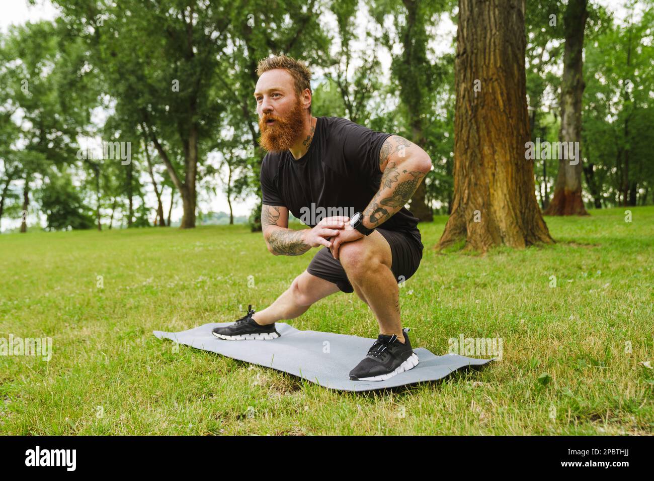 Ginger bearded man doing exercise during workout in park outdoors Stock ...