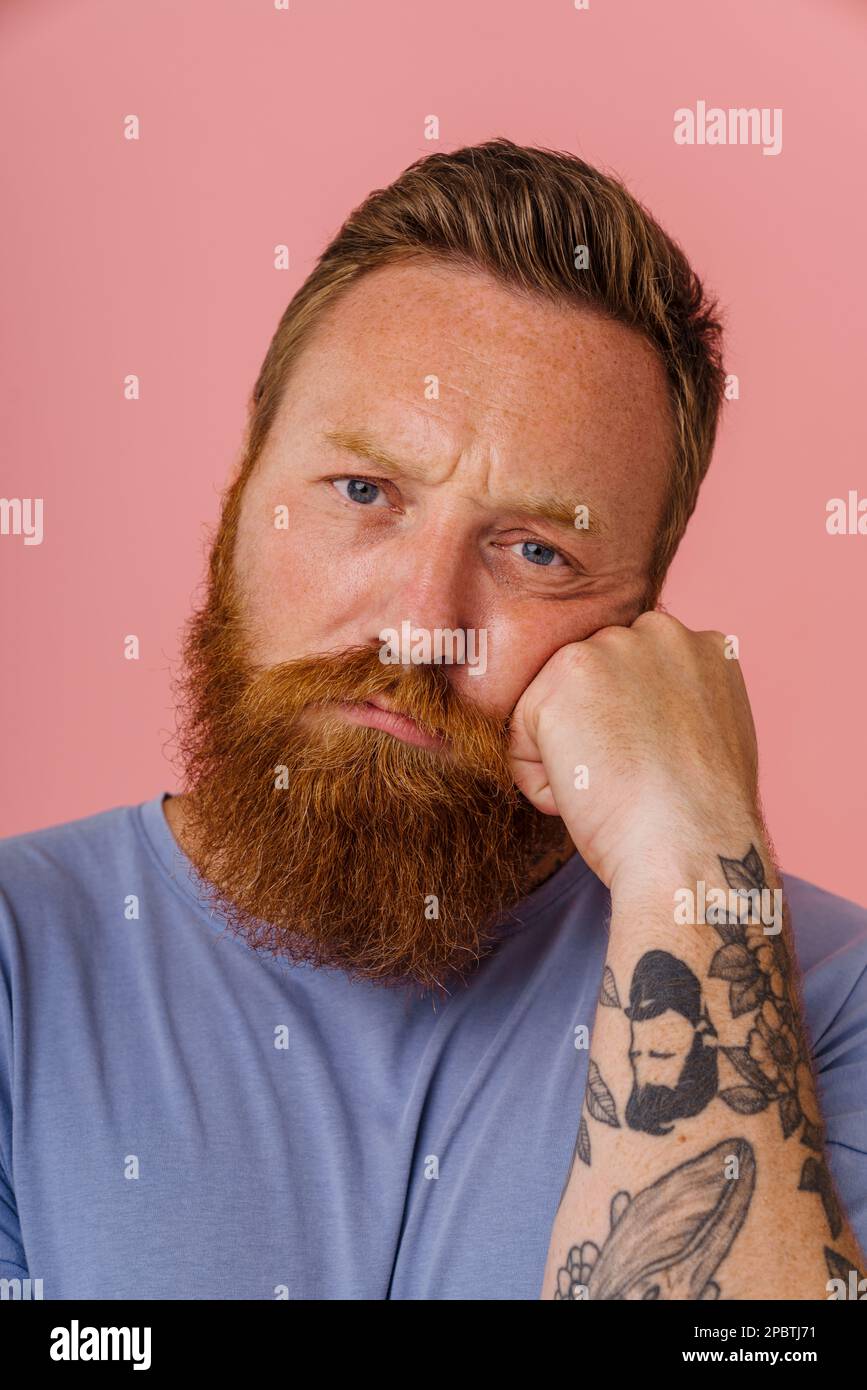 Ginger perplexed man with beard frowning and looking at camera isolated ...