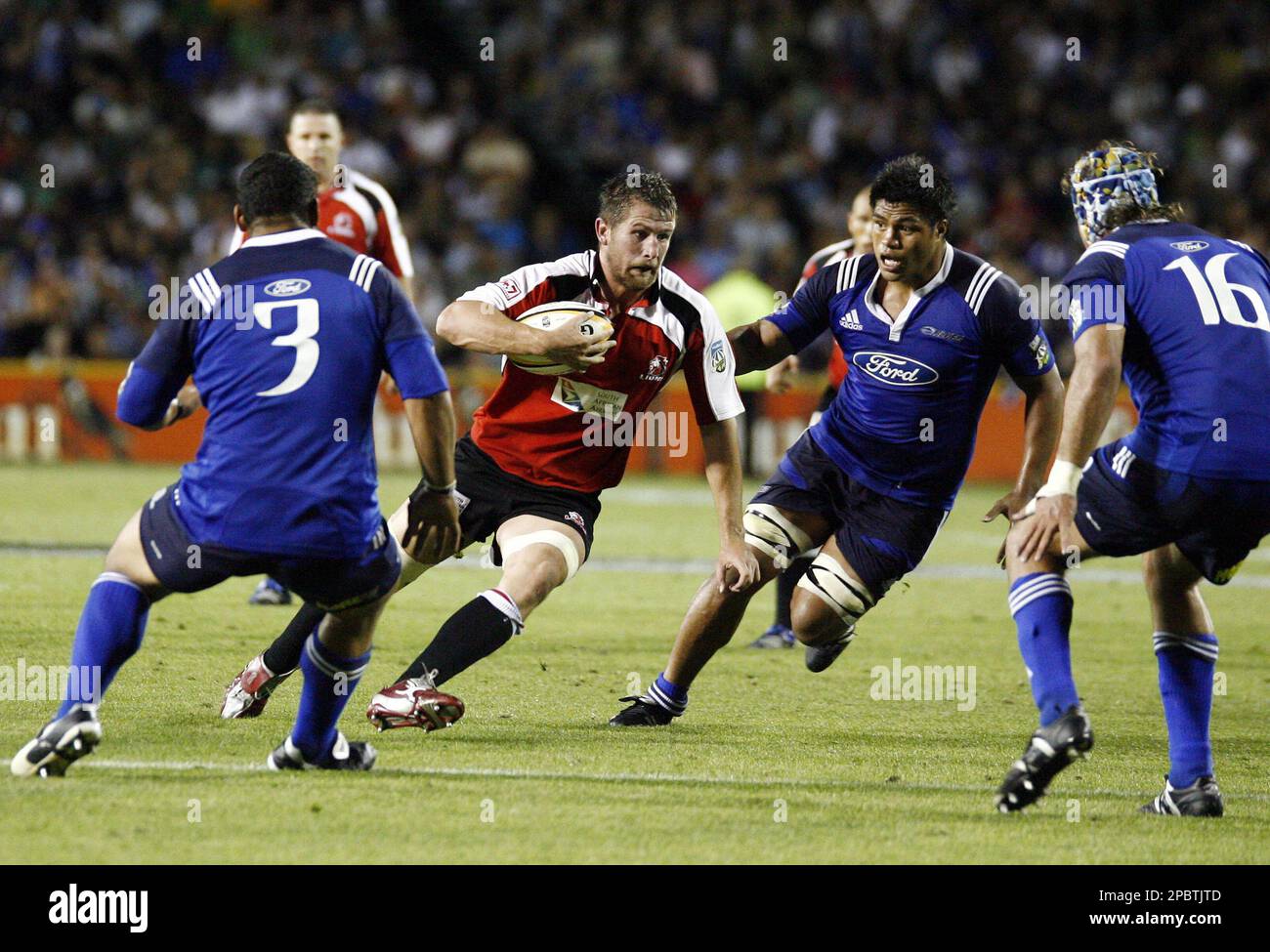 South African Lions' Ernst Joubert, in red, spots a gap in defense of ...