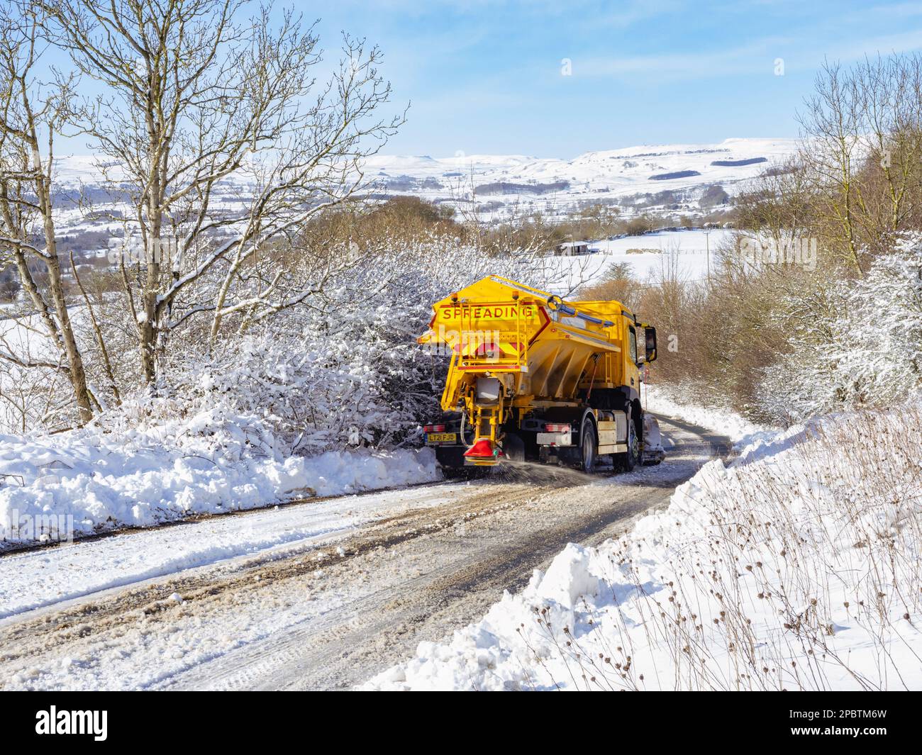 Grit lorry spreading grit on a snowy road Stock Photo - Alamy