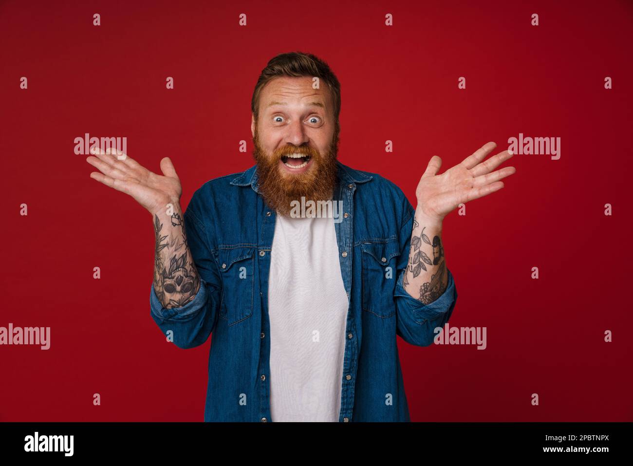Ginger Shocked Man With Tattoo Expressing Surprise At Camera Isolated