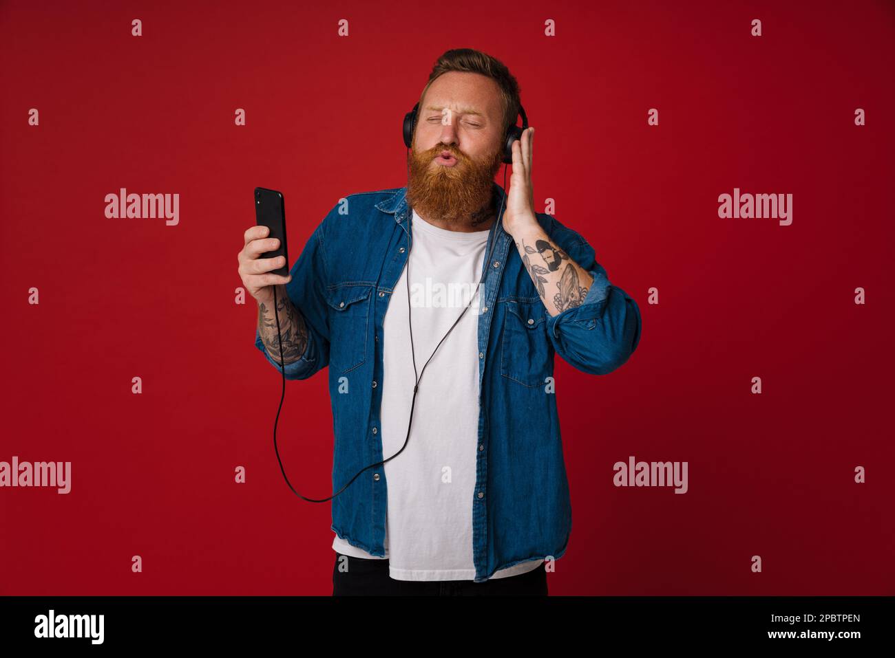 Ginger white man singing and dancing while listening music isolated ...