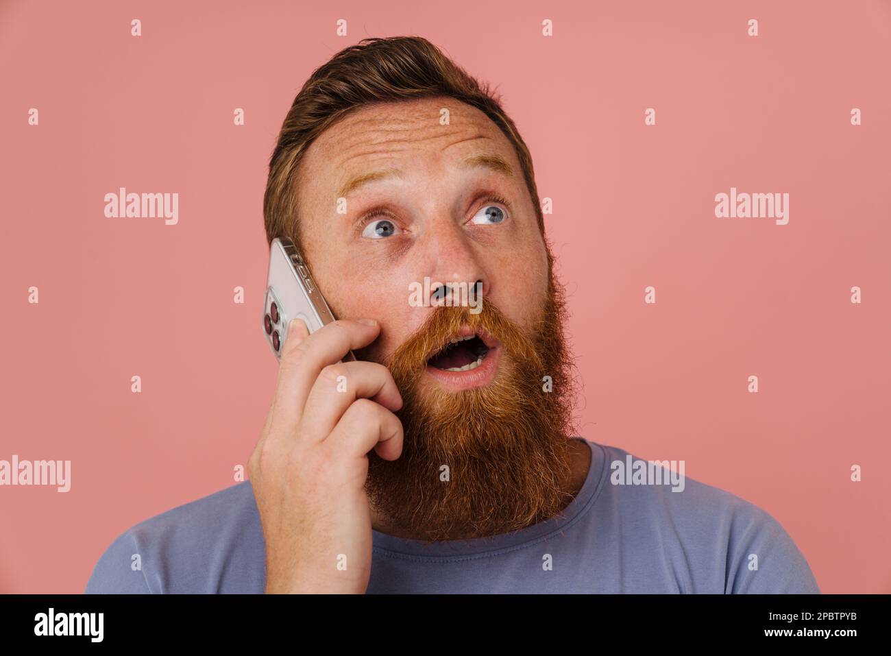 Ginger white man talking on cellphone and expressing surprise isolated ...
