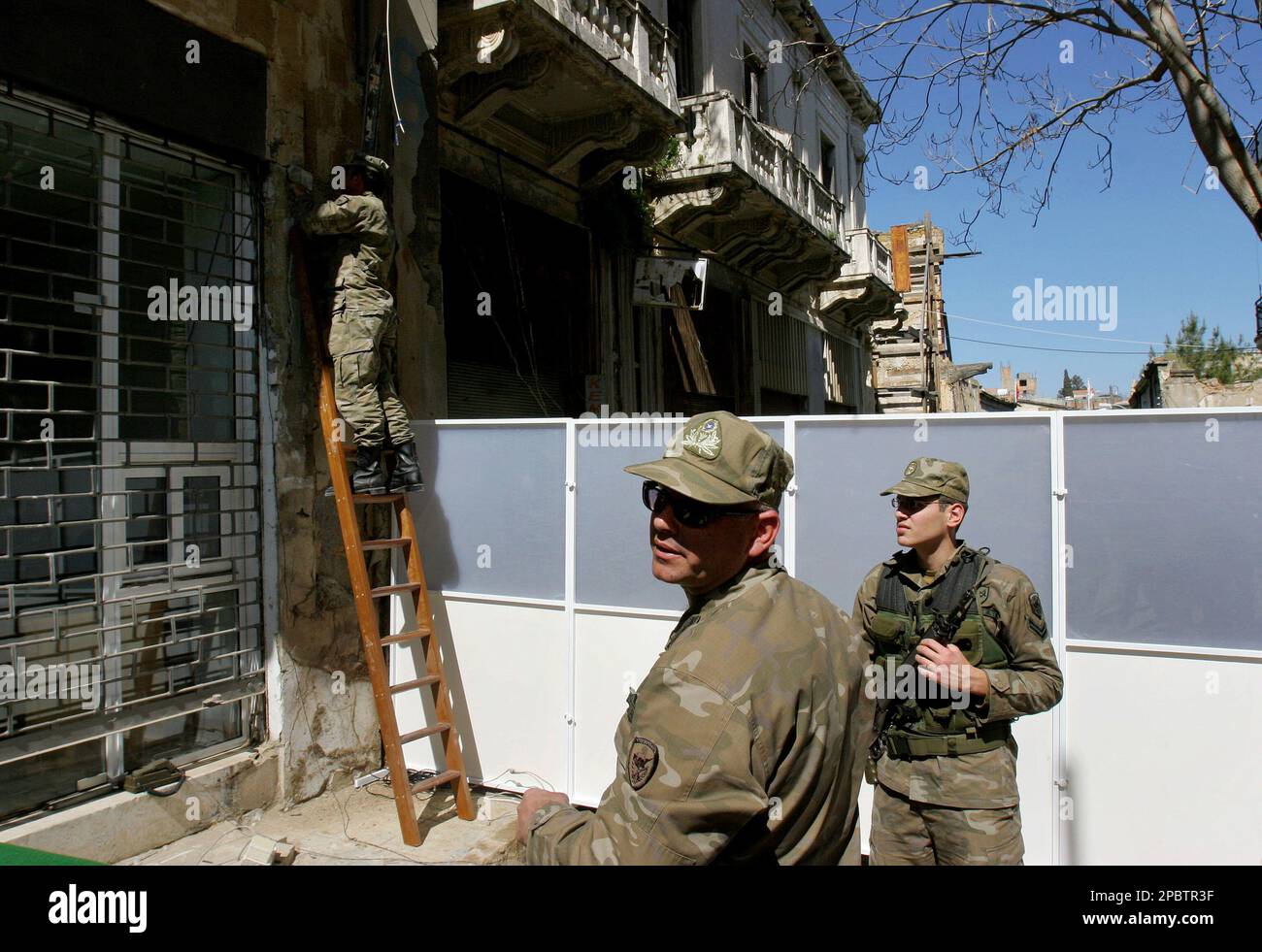 Cypriot soldiers stand in front of a temporary barrier after they ...