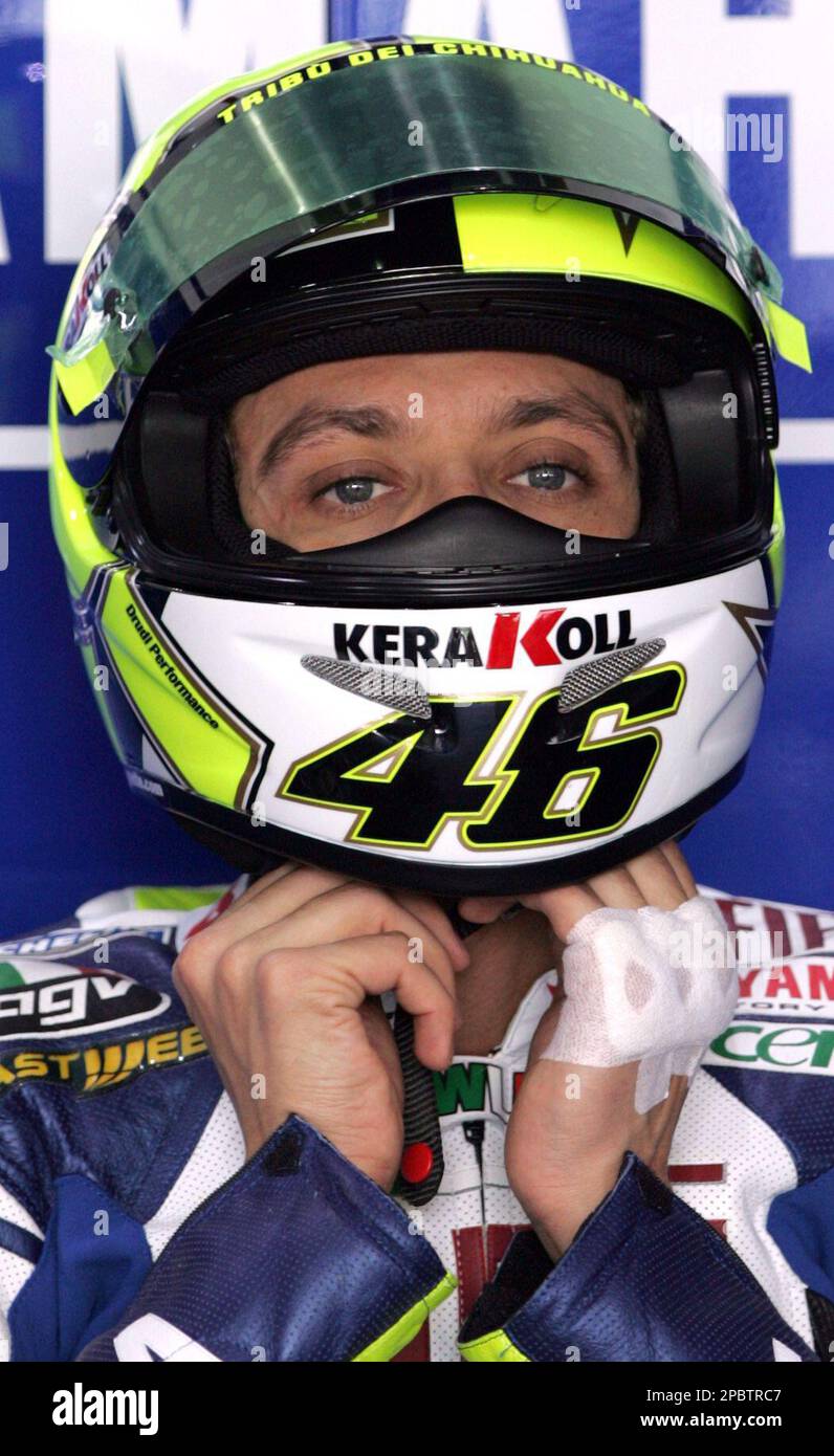 Yamaha MotoGP rider Valentino Rossi of Italy puts on his helmet before ...