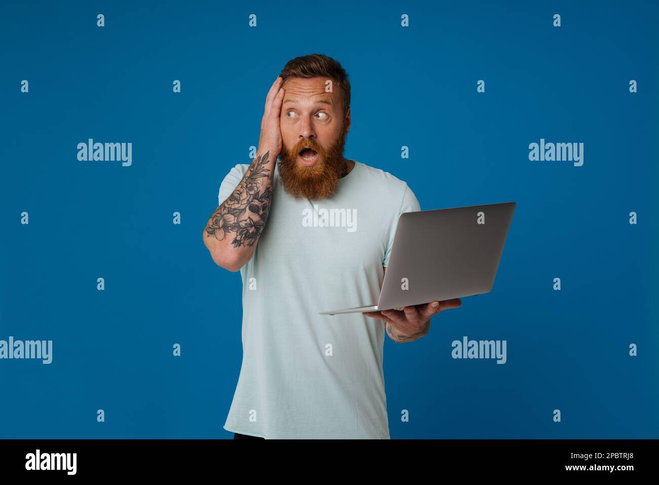Ginger Shocked Man Expressing Surprise While Working With Laptop