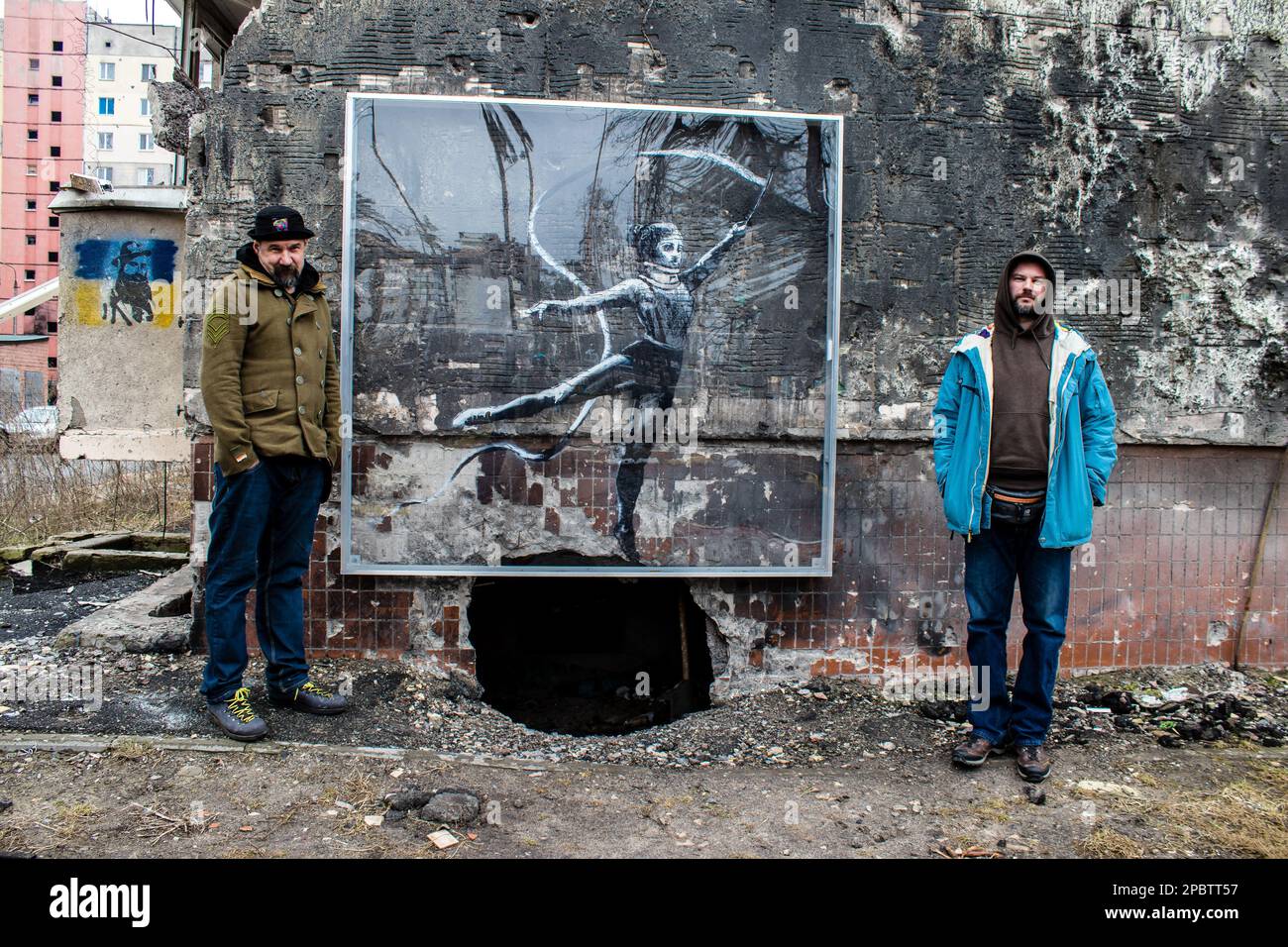 Two Ukrainian people standing near the "Girl gymnast" Mural by Banksy ...