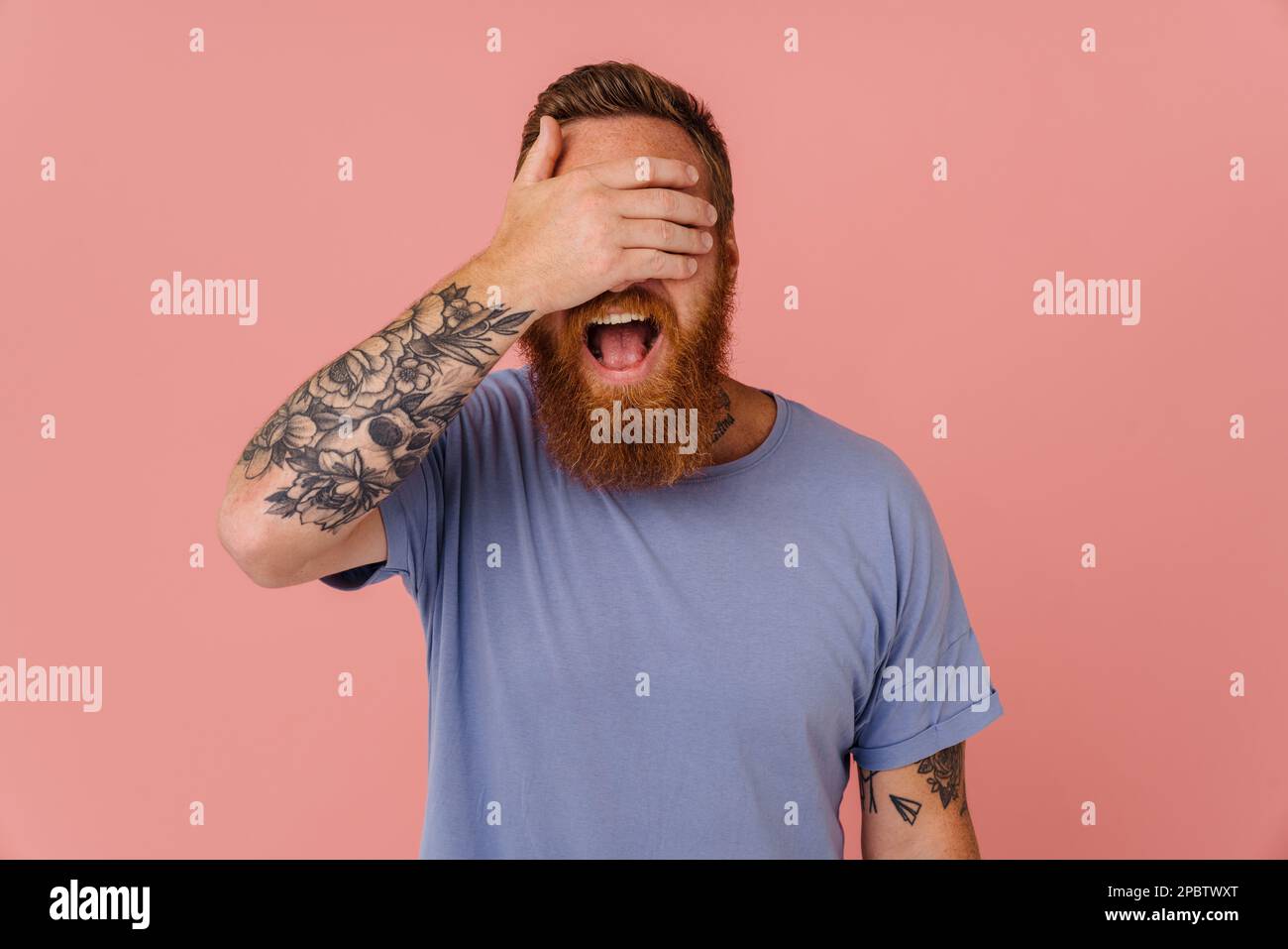 Ginger excited man with beard screaming while covering his eyes ...