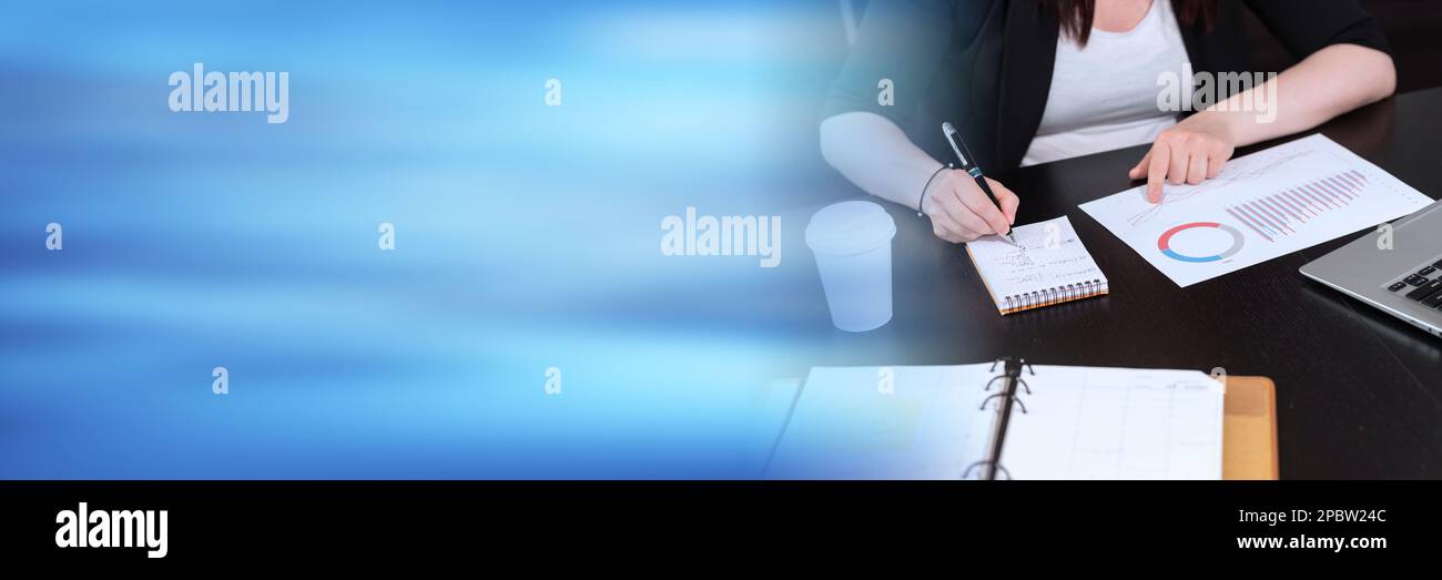 Businesswoman analysing marketing data and taking notes; panoramic ...