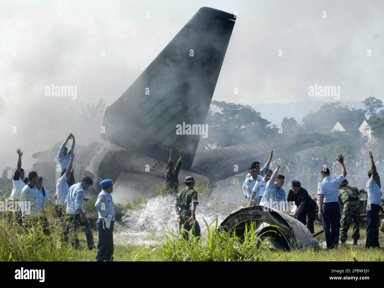 Indonesian Air Force personnel try to extinguish the flame from a ...