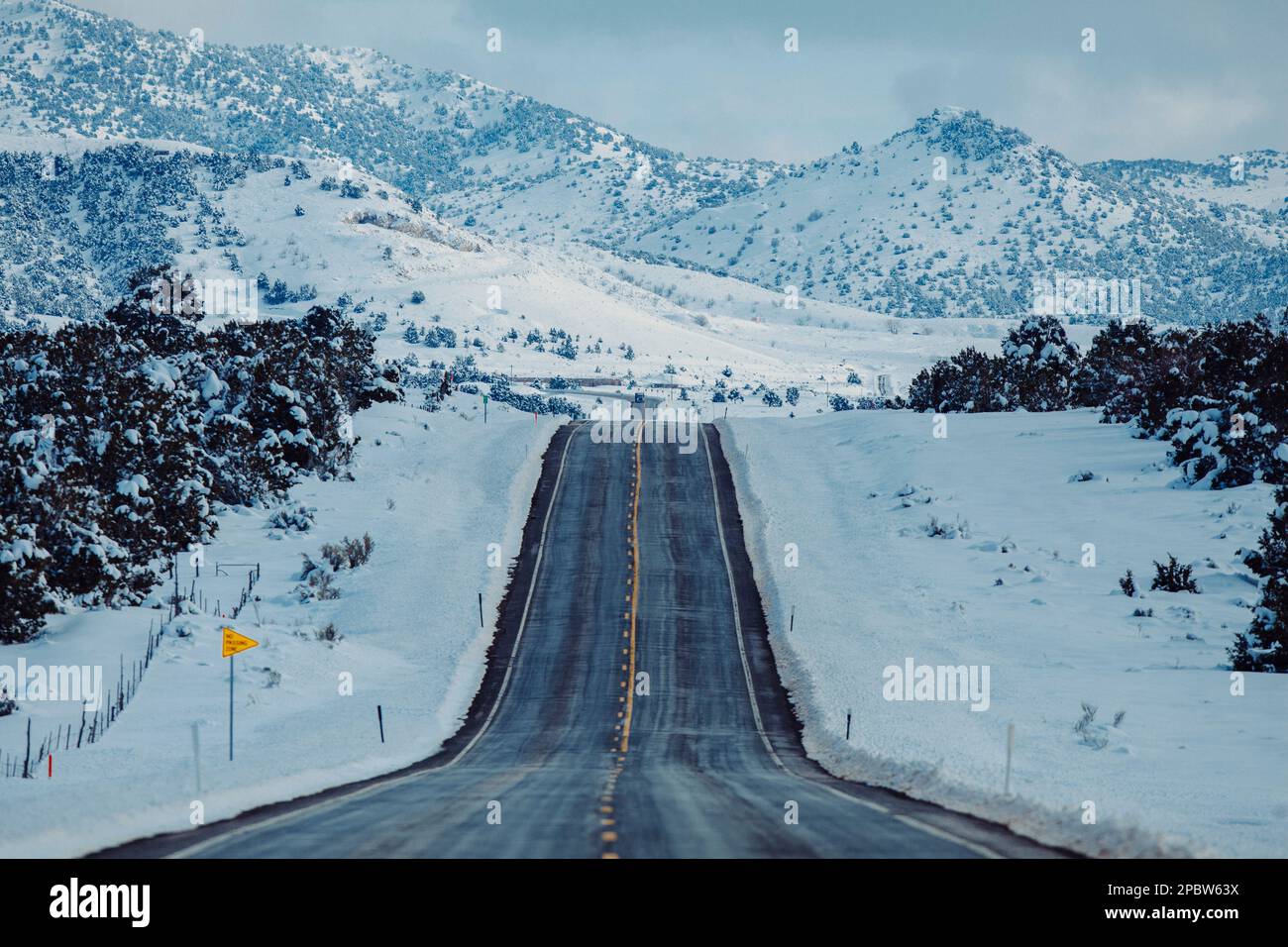 Snow covers a long road cutting through the mountains Stock Photo - Alamy