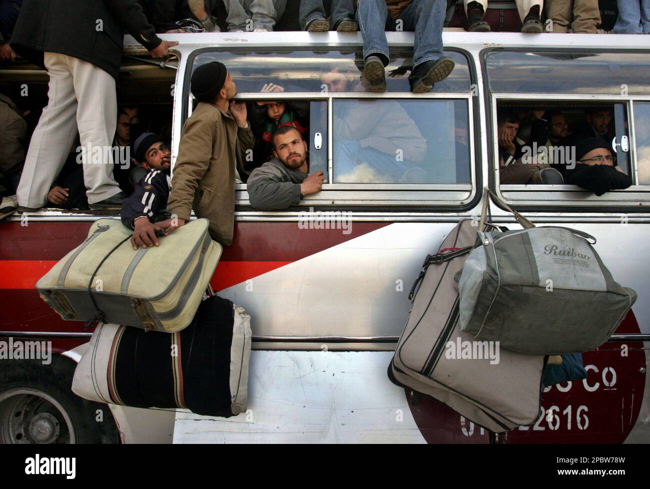 Palestinians are seen in and on top of buses as they wait to cross the ...