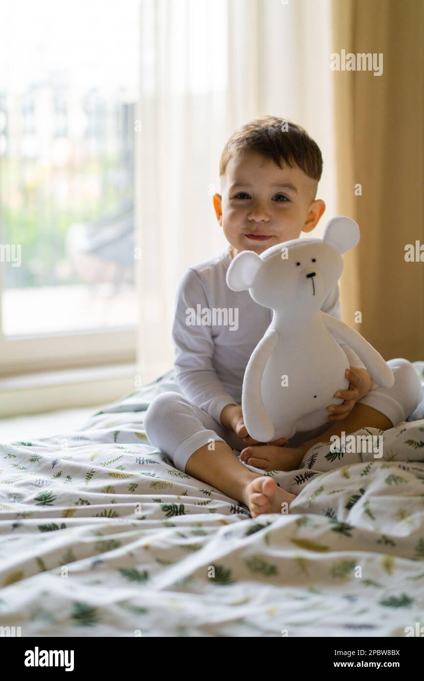 Happy little child boy in pajamas, in bed in the bedroom with to Stock ...