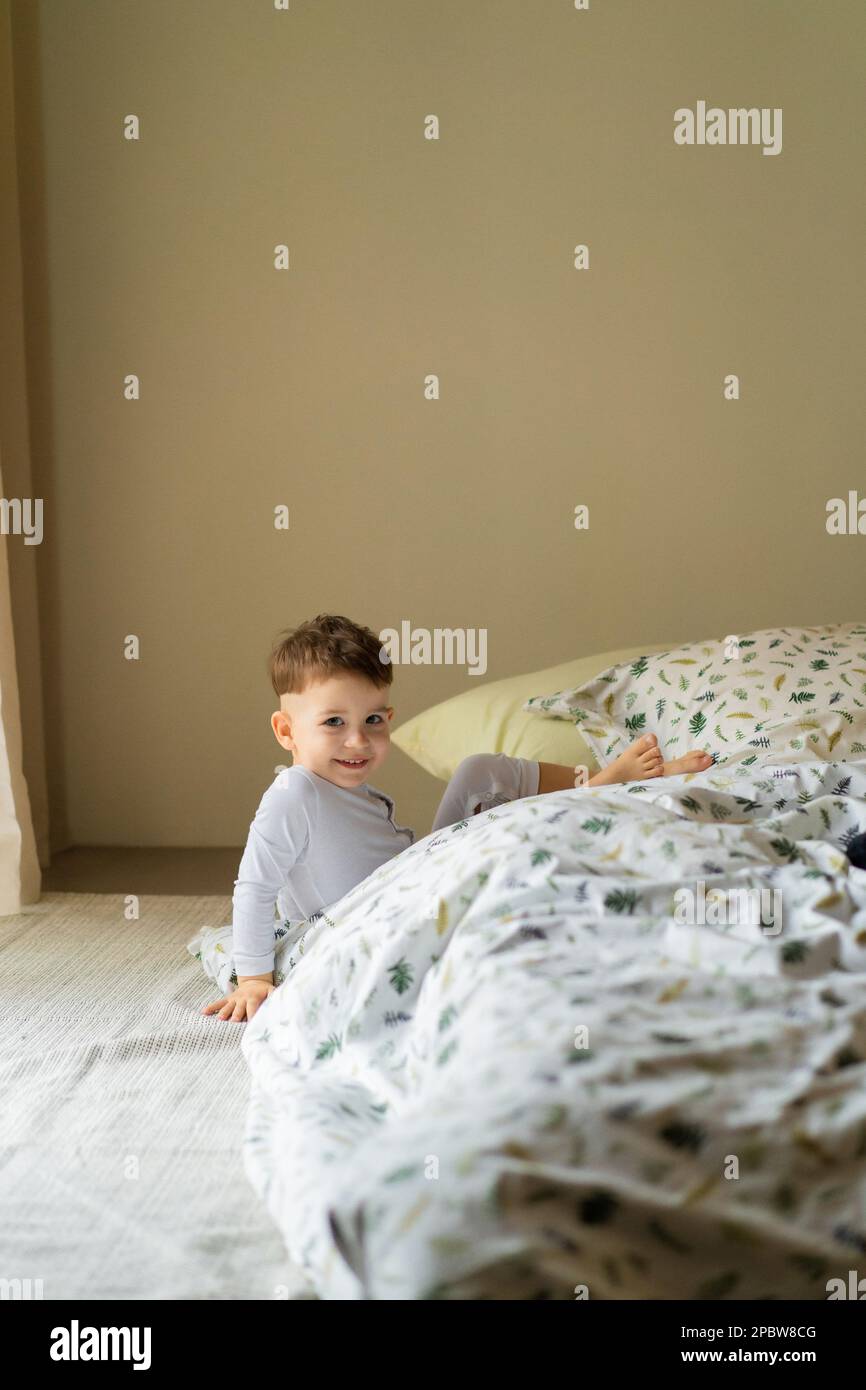 Happy little child boy in pajamas, in bed in the bedroom with to Stock ...
