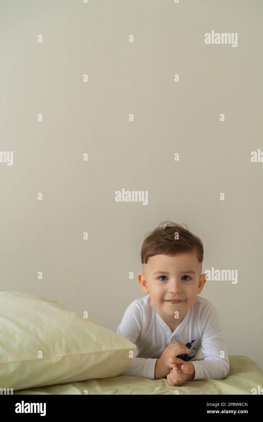 Happy little child boy in pajamas, in bed in the bedroom with to Stock ...