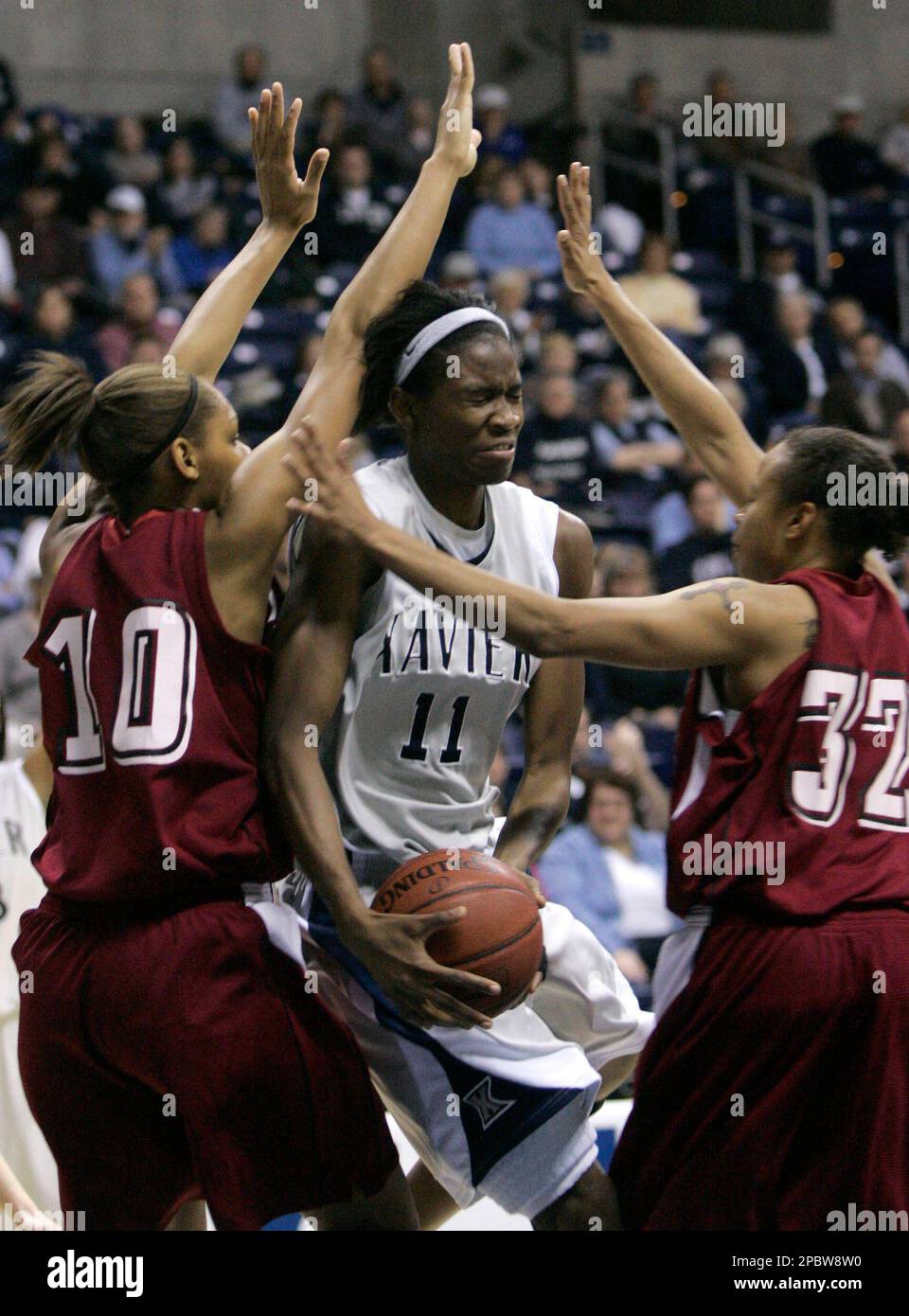 St. Joseph's Brittany Ford (10) and Timisha Gomez (32) block Xavier's ...