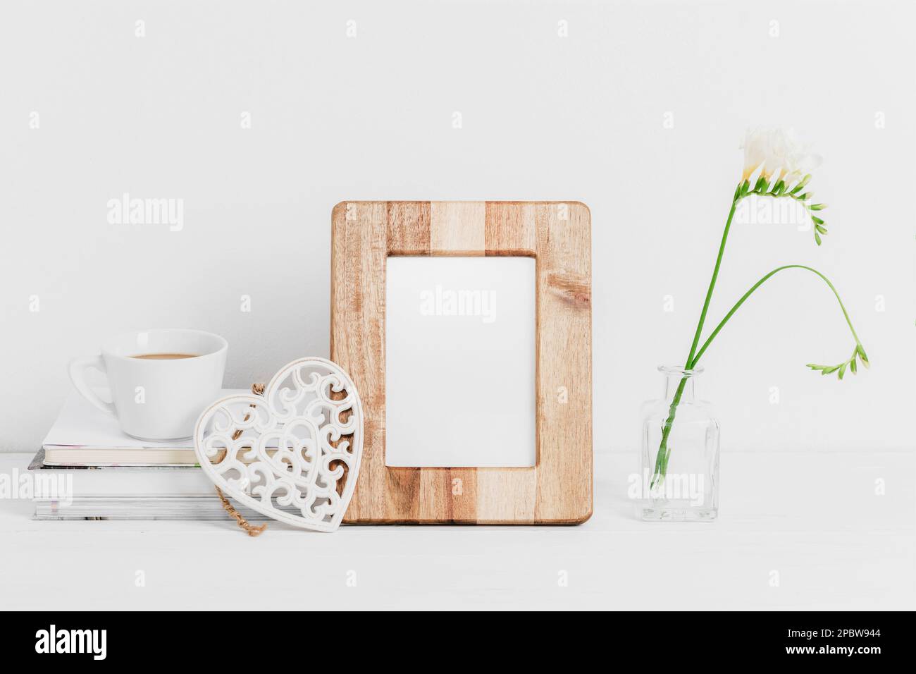 Mockup wooden picture frame, books, coffee cup, carved decor heart and ...
