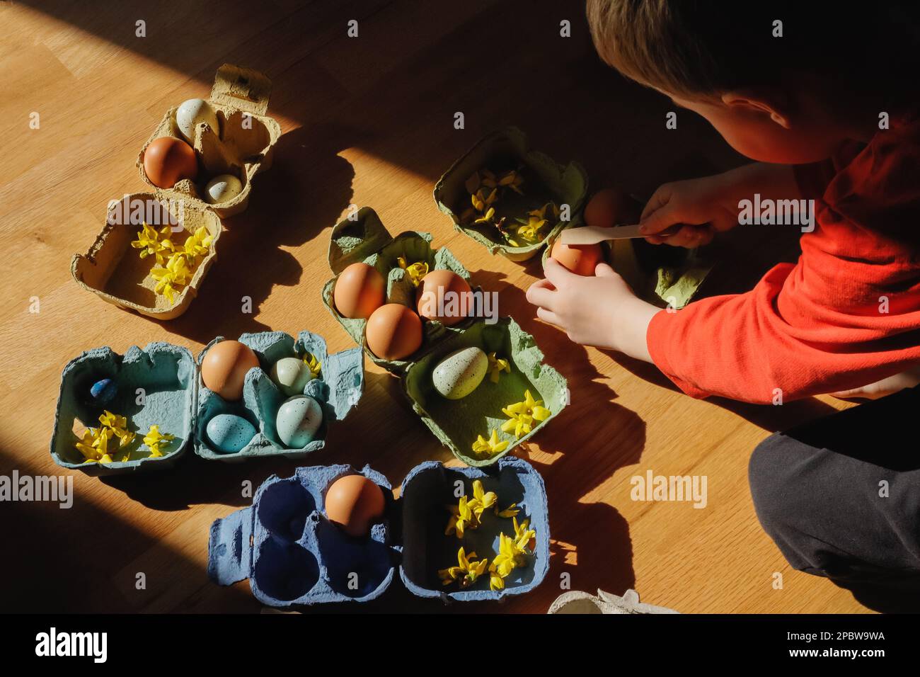 easter eggs in boxes and a child playing with them Stock Photo - Alamy