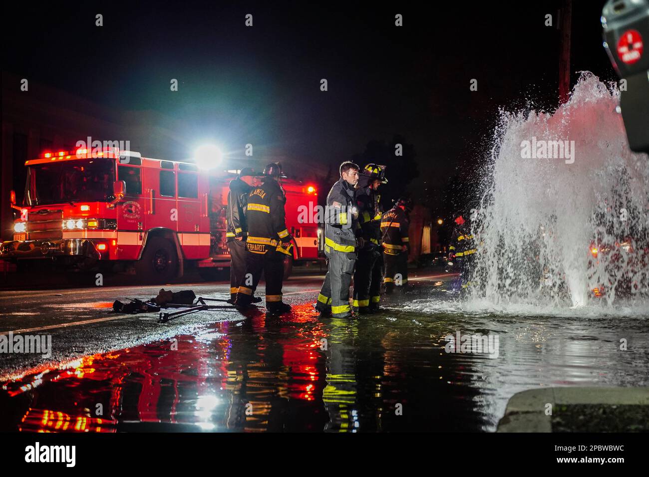 Firefighters work on the fire hydrant. A fire hydrant located at the ...
