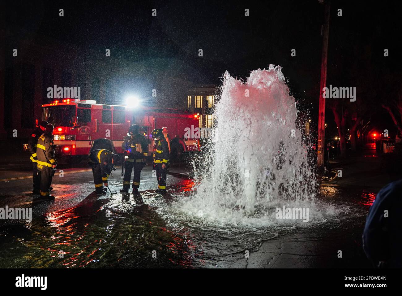 Firefighters discuss the solution on how to stop water. A fire hydrant ...