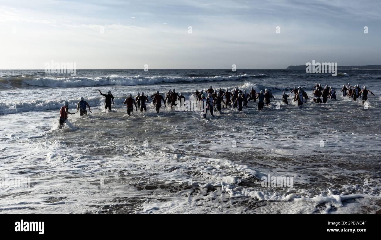 Triathlon Athletes Swim Start beach entering ocean waves surf for ...