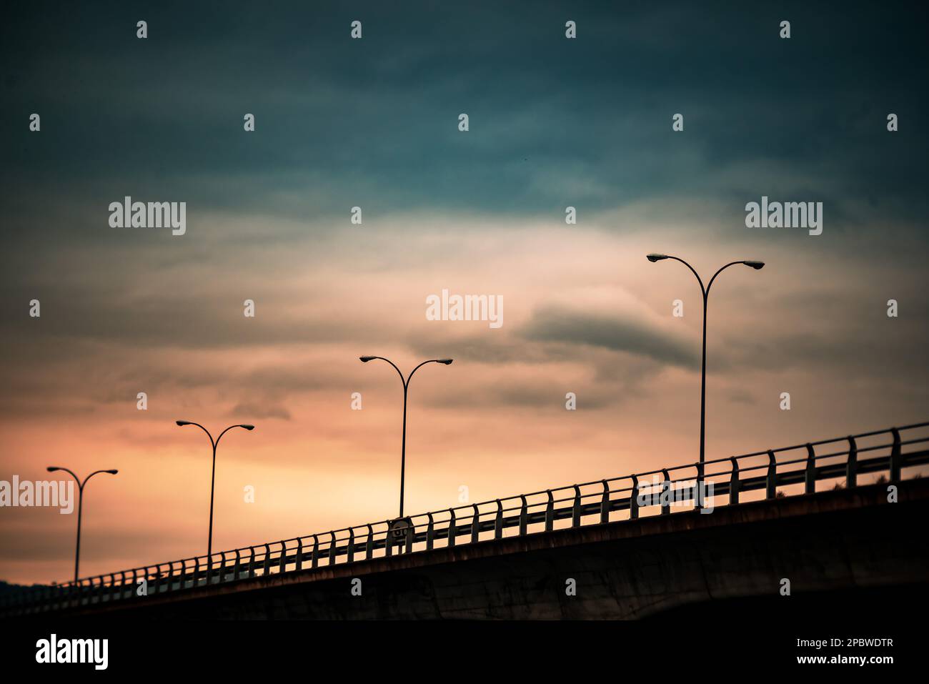Golden Gateway: Bridge Under Cloudy Sunset Sky Stock Photo - Alamy