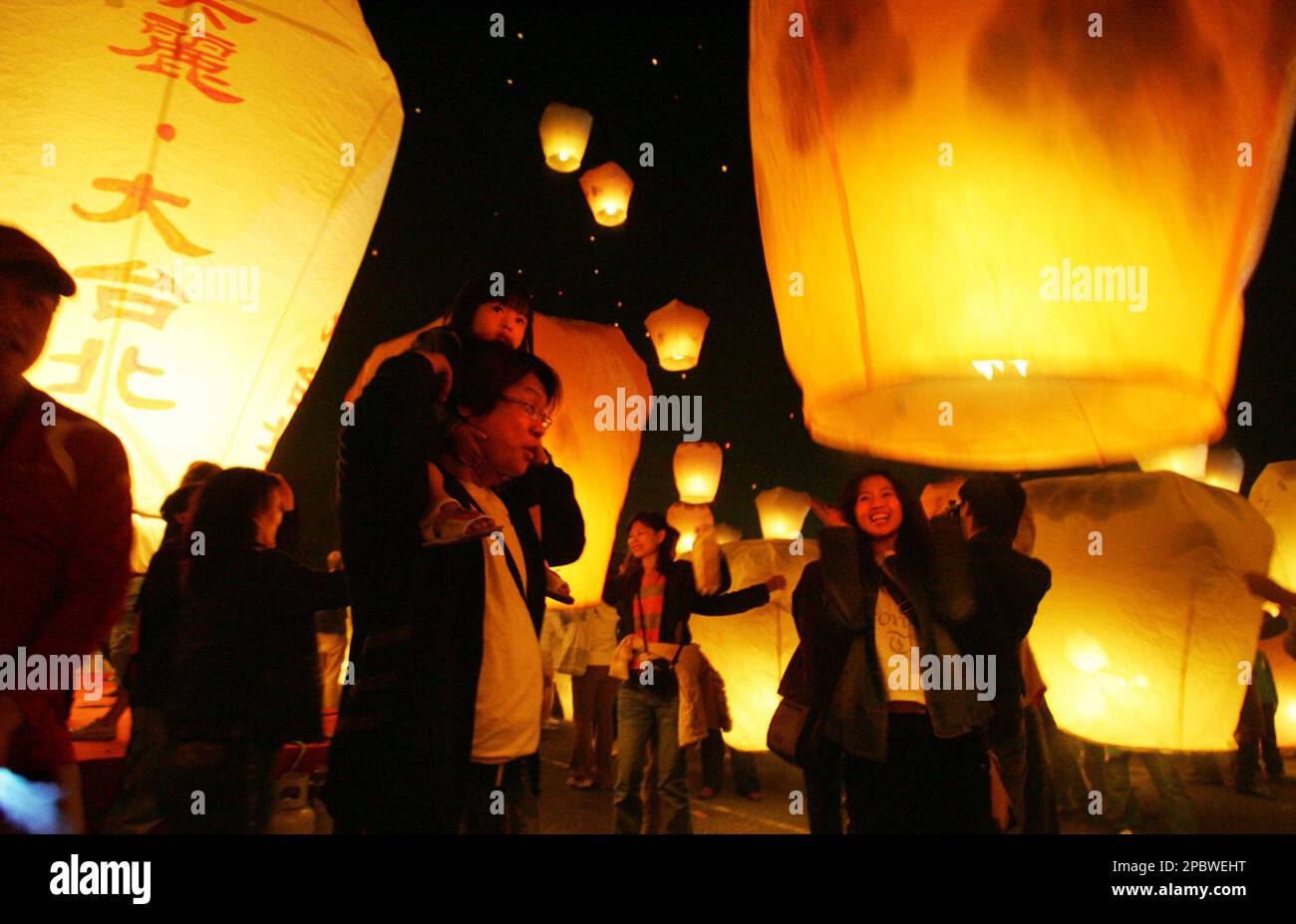 A Taiwanese family releases a "sky lantern" to celebrate the ...
