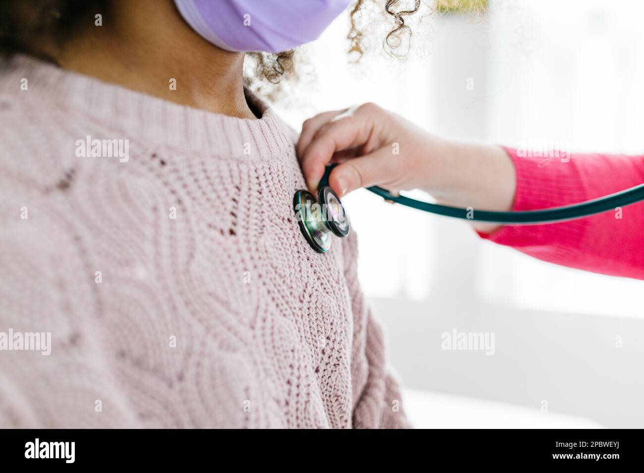 Stethoscope placed directly over biracial child's heart beat to listen ...