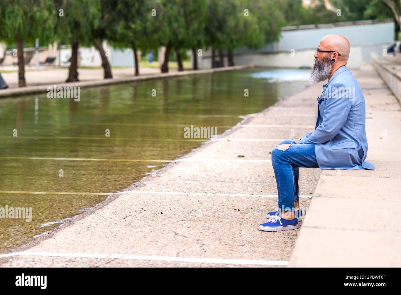 middle-aged, balding, bearded man sitting in a park relaxing Stock ...