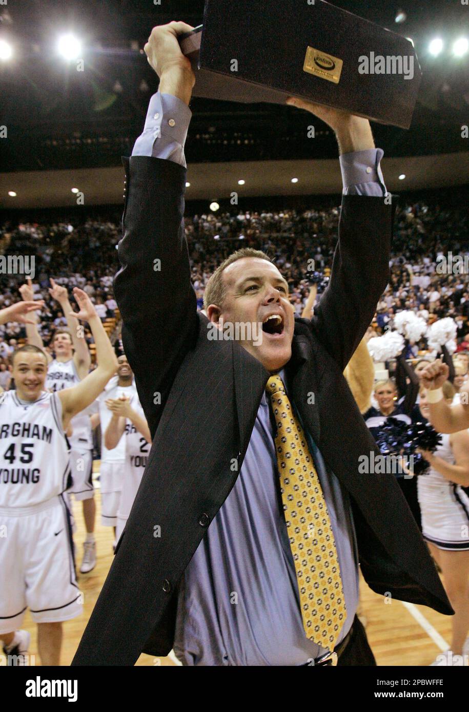 Brigham Young coach Dave Rose celebrates with the Mountain West trophy ...