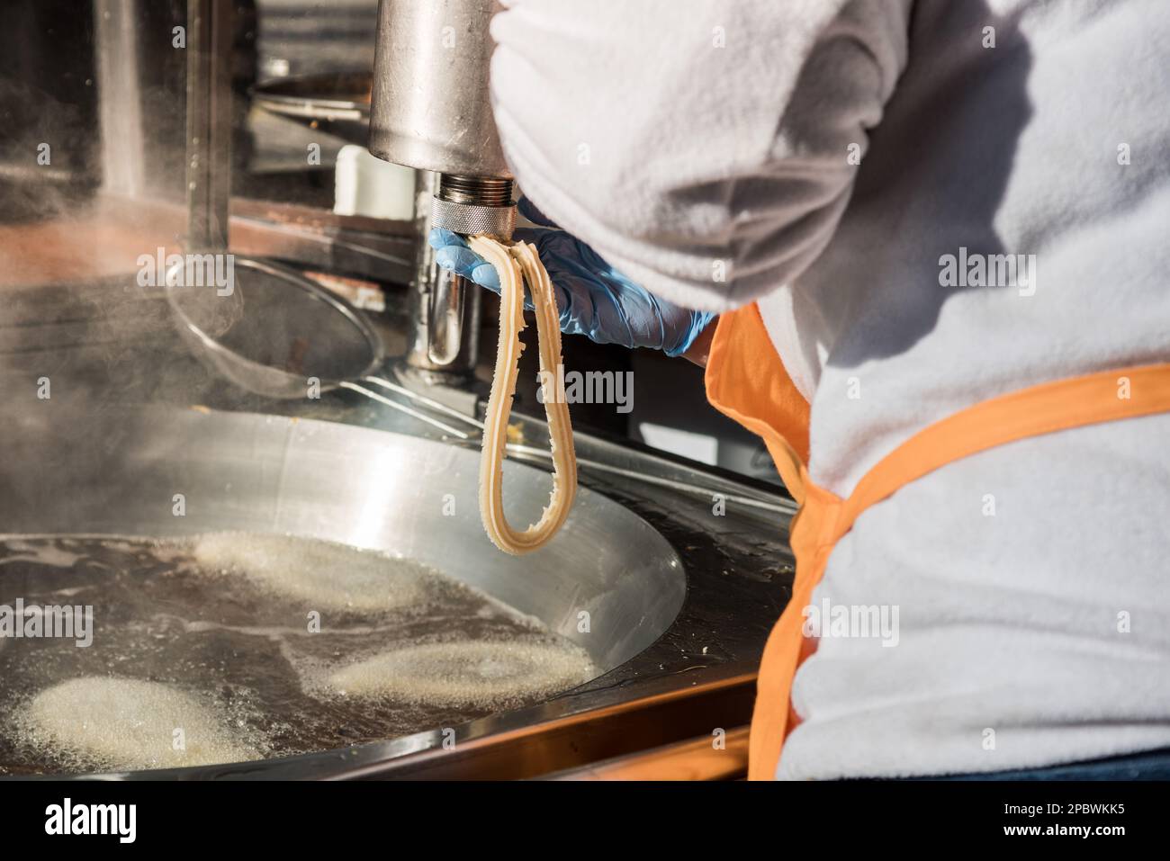 Detail of worker making churros on the industrial metal kitchen Stock ...