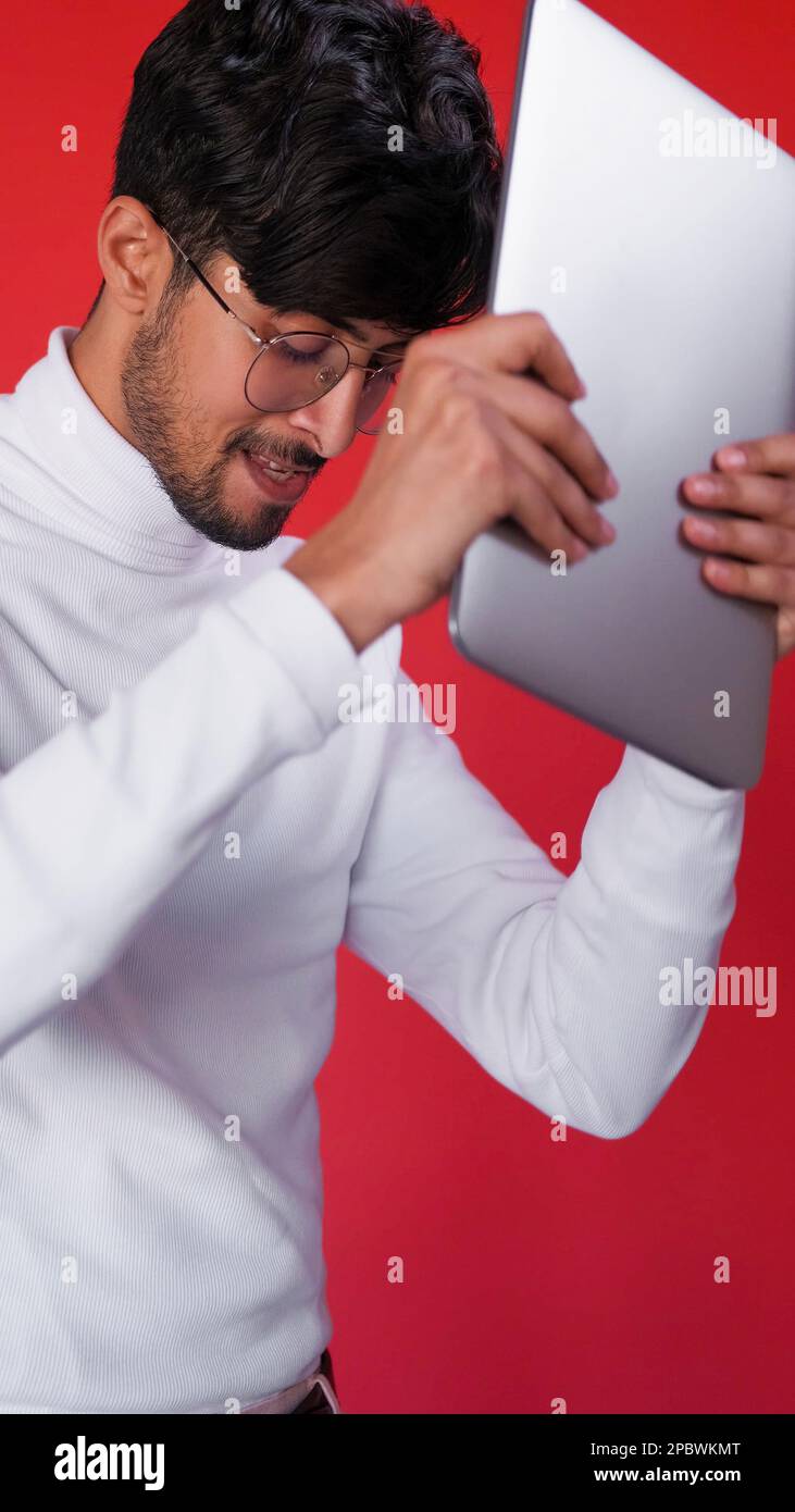Angry developer annoyed mad guy crashing laptop Stock Photo - Alamy