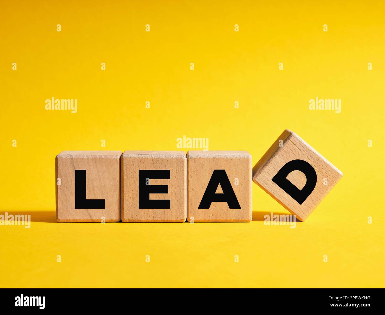 The word Lead on wooden cubes with yellow background. Team or market ...