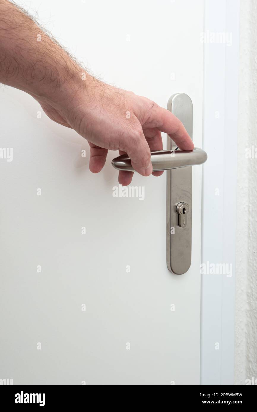 Caucasian male hand opening a door lever from inside apartment. Close ...