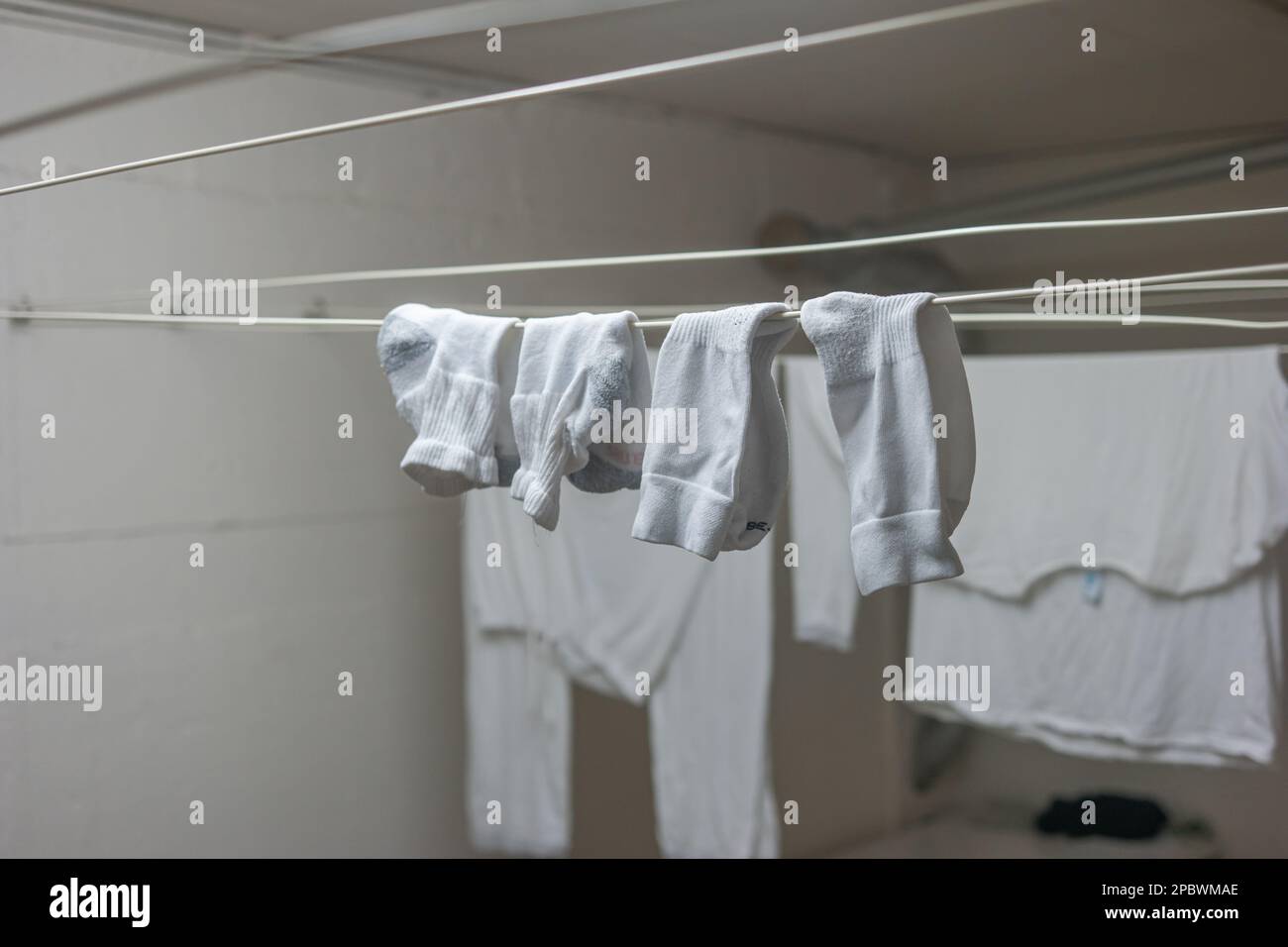 White pajamas or clothing and short socks hanging from drying lines ...