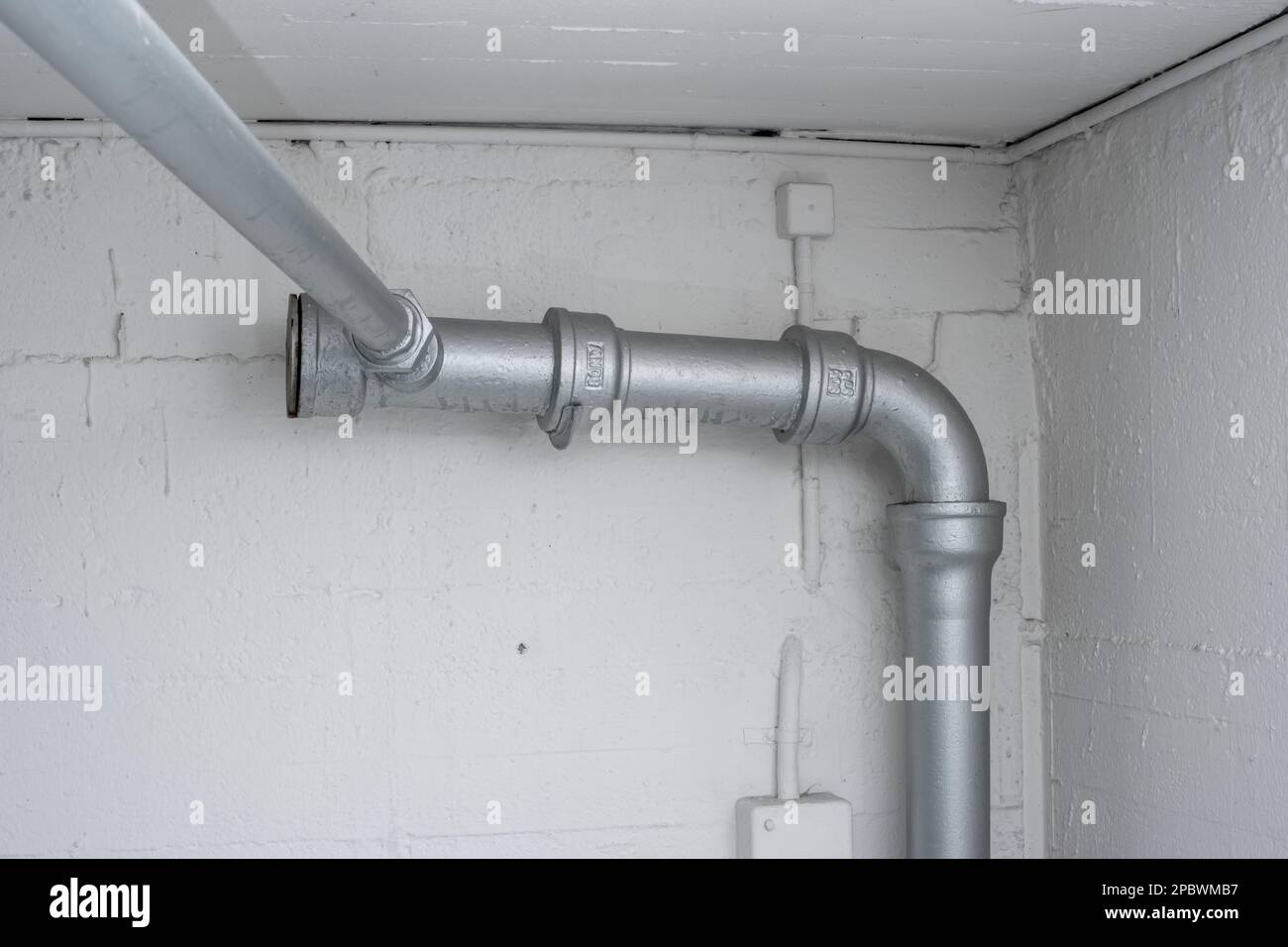 Thick plastic plumbing twisting tubes inside communal laundry room ...