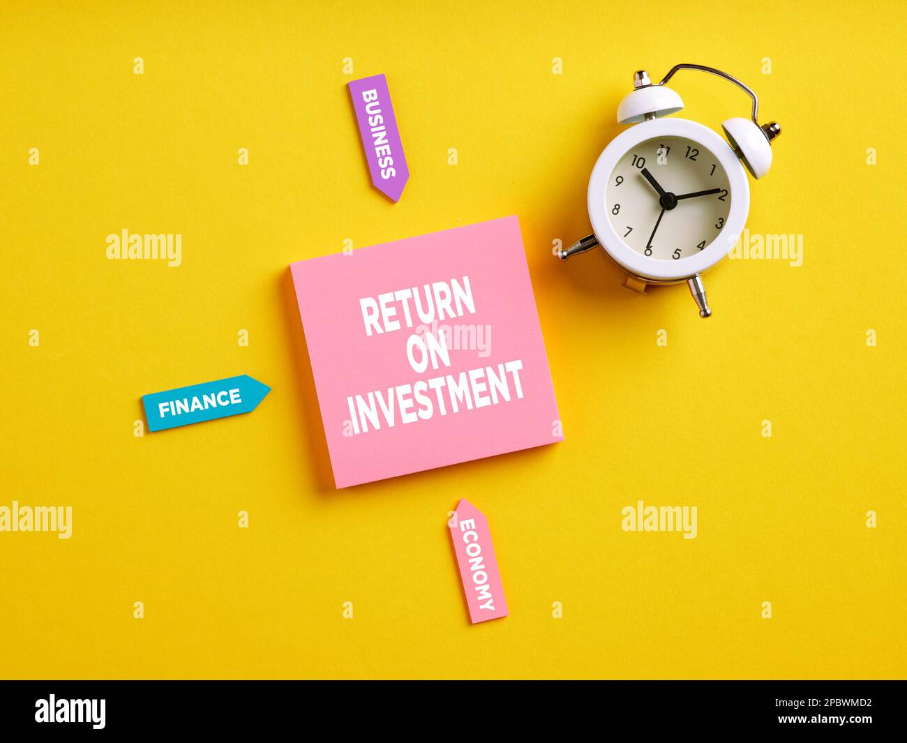The word return on investment on pink note paper. Business investment ...